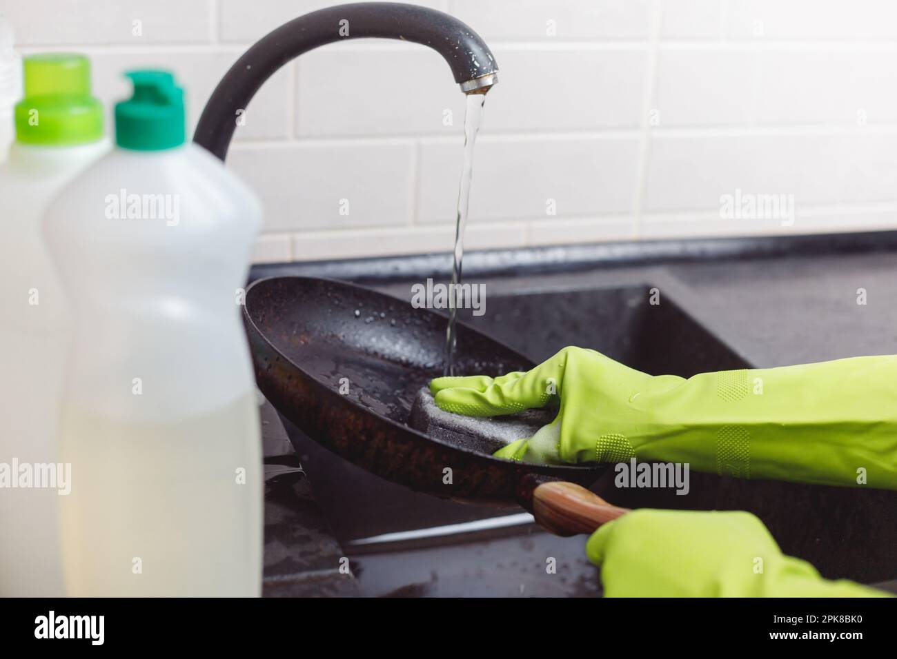 Person in Green Glove Washing Frying Pan with Sponge under Running ...