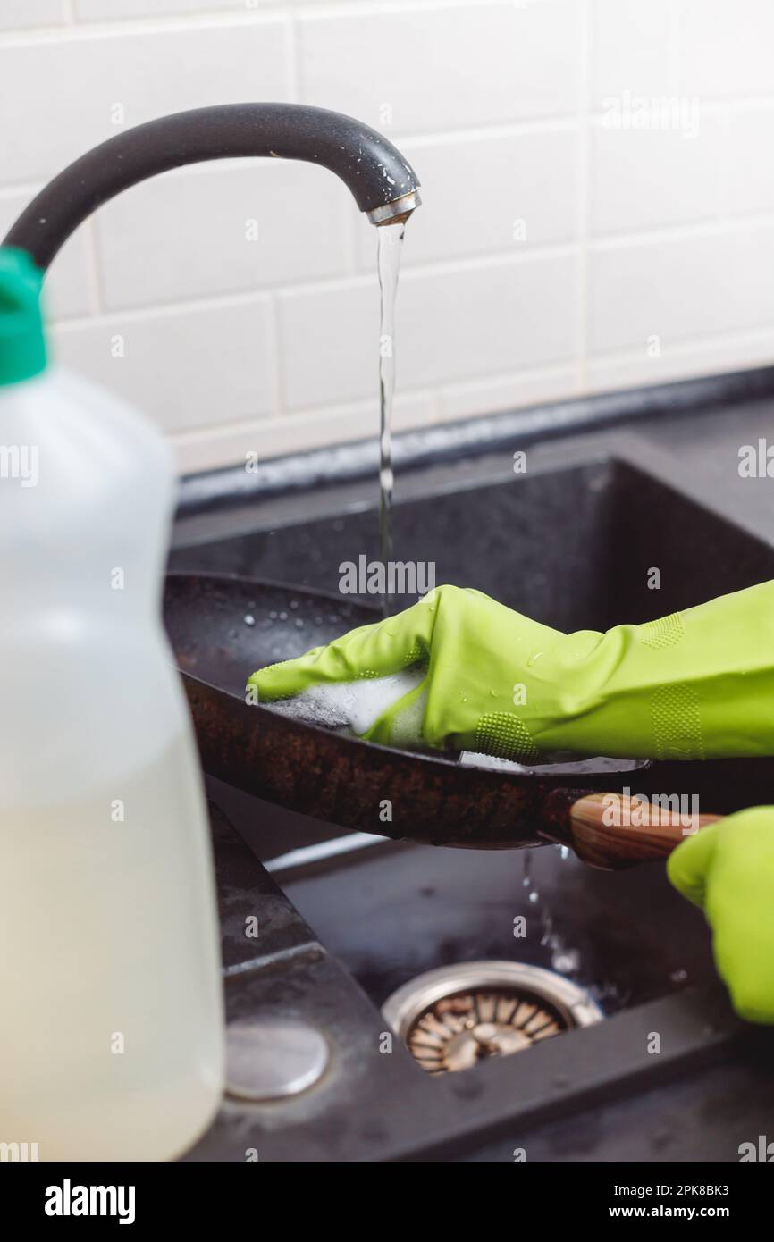 Washing frying pan in sink hi-res stock photography and images - Alamy