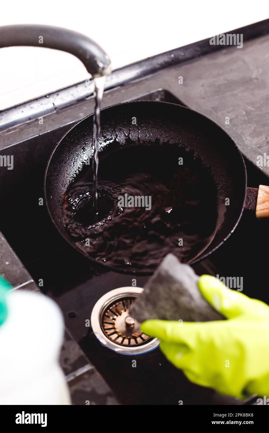 Person in Green Glove Washing Frying Pan with Sponge under Running ...
