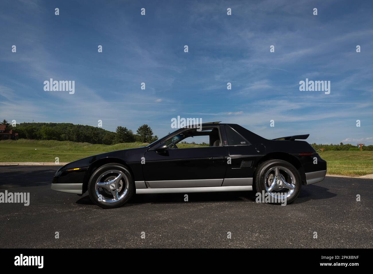 A sleek black and silver colored car parked on the pavement in a city ...