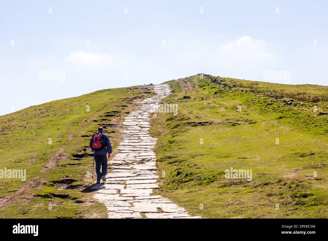 Man climbing the flagstones up to the summit of Mam Tor the highest ...