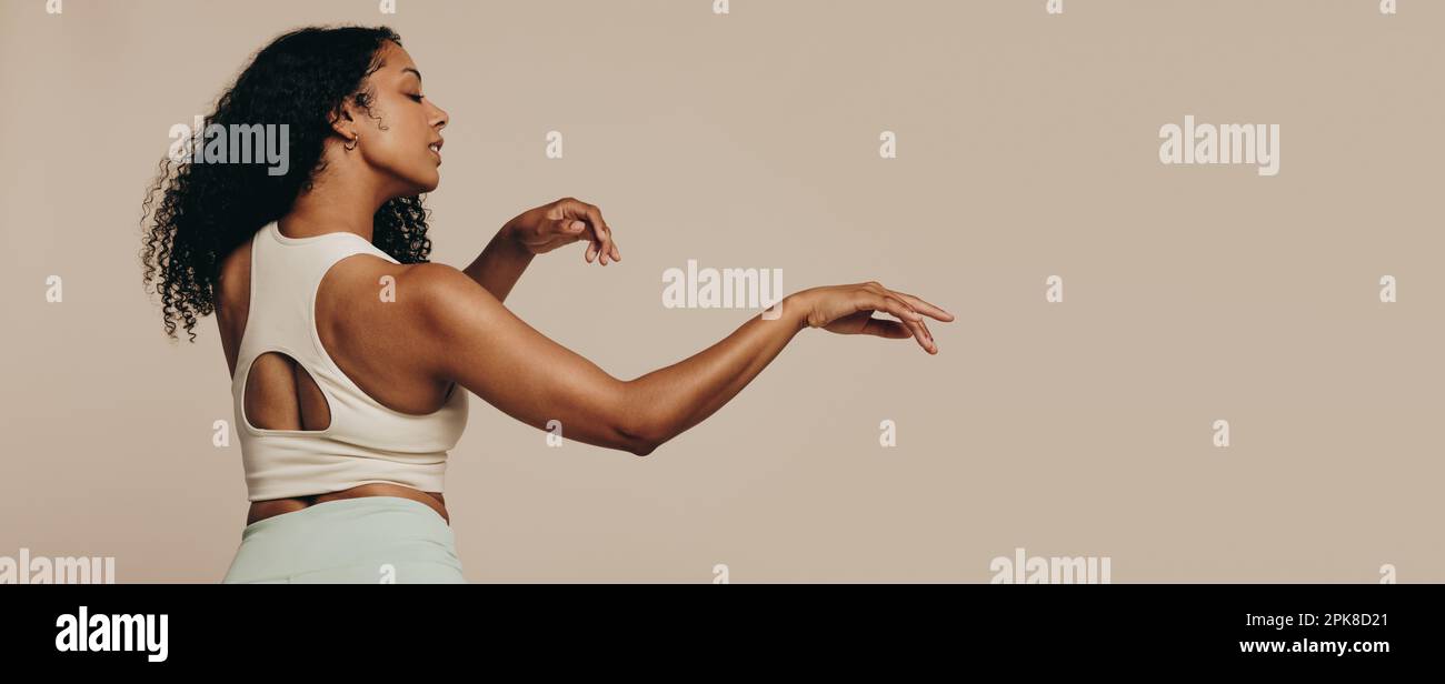 Fit woman dancing in a studio, moving her body effortlessly in fitness ...