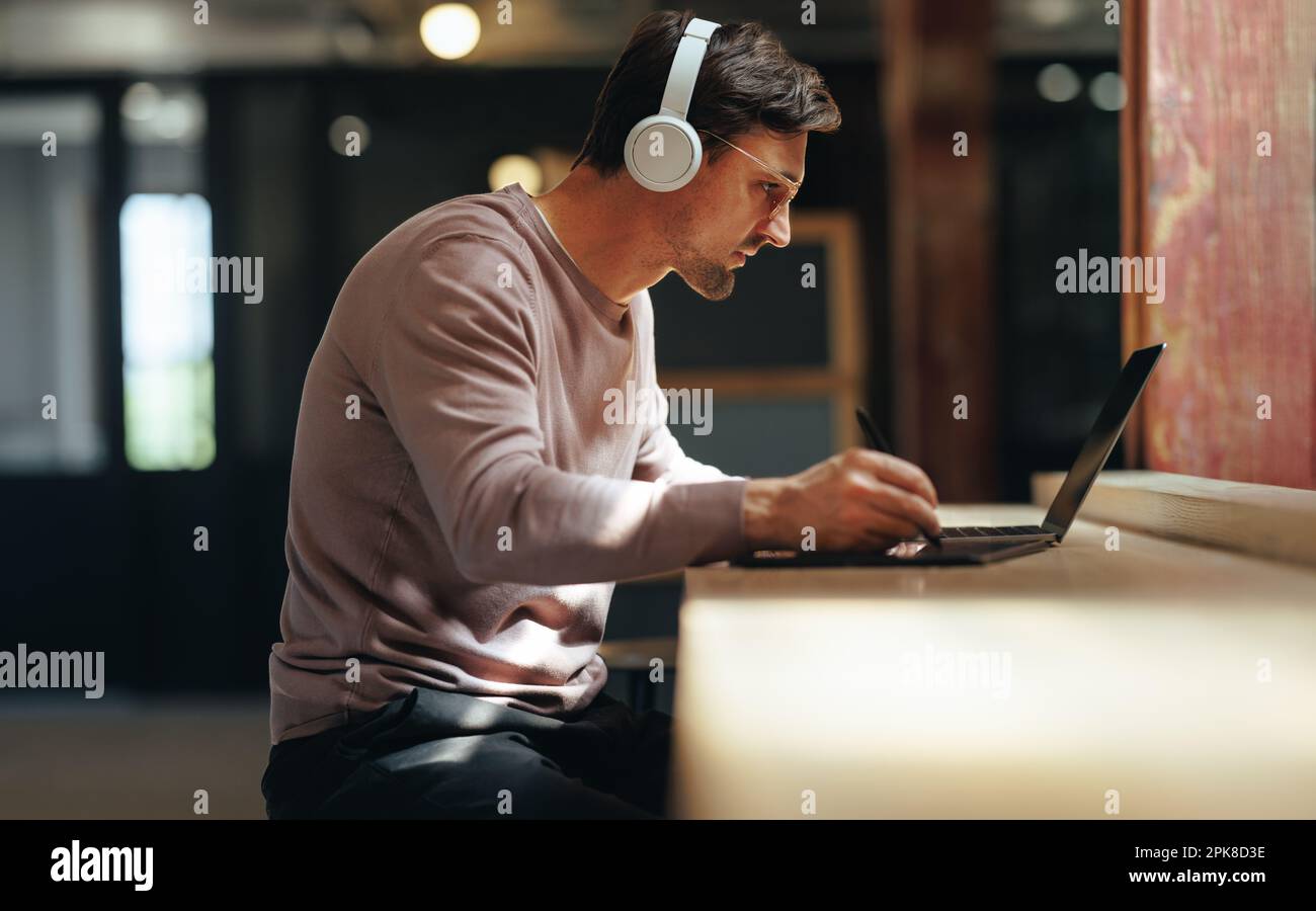 Freelance web designer working with a graphics tablet and a laptop ...