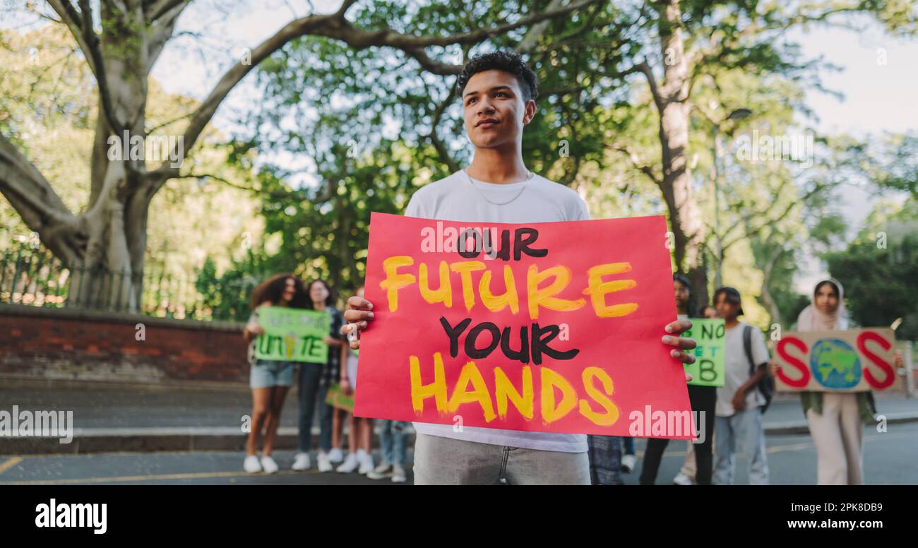 Young activist looking away while holding a banner sign during a ...