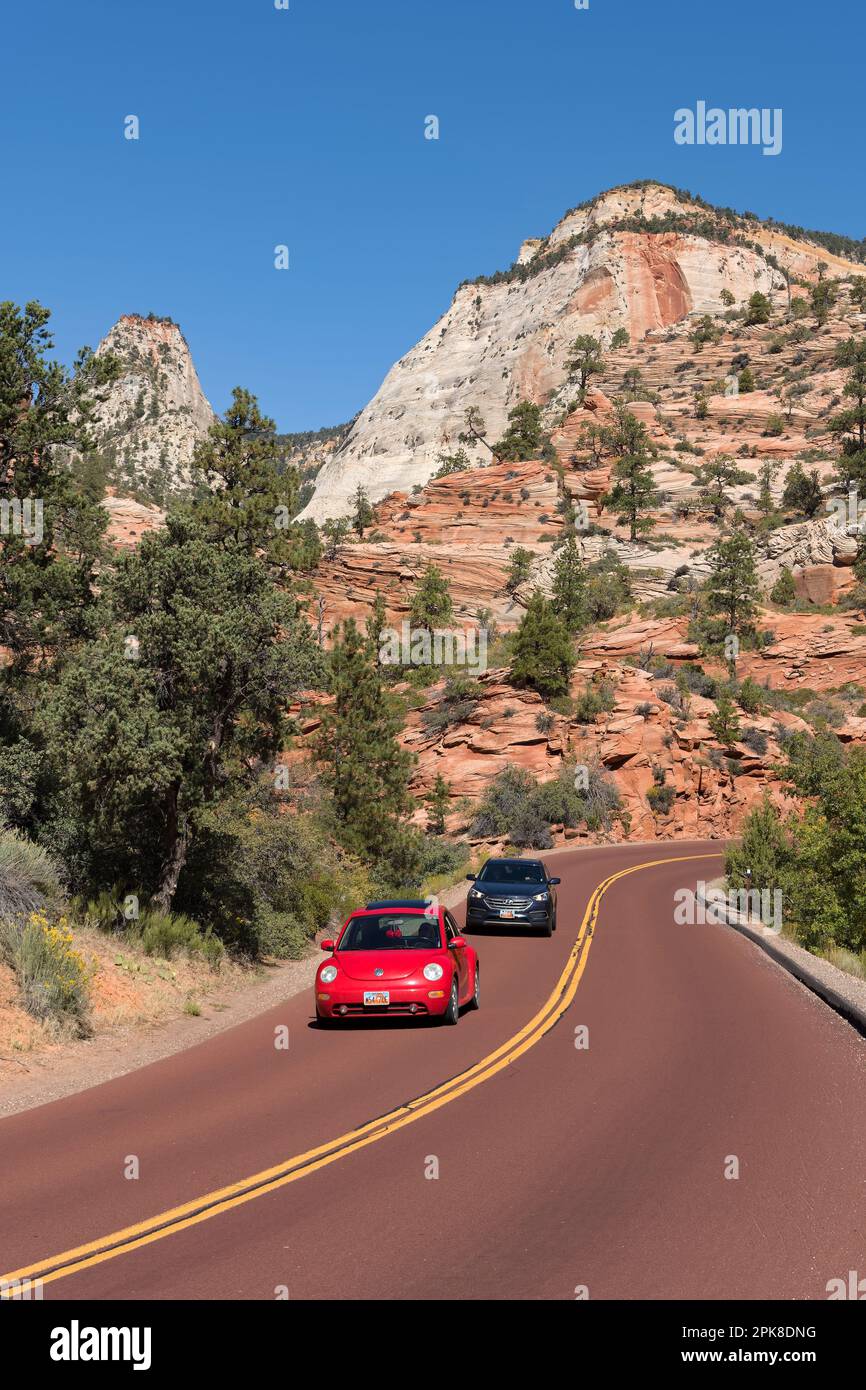 red VW Beetle driving on scenic road Zion-Mount-Carmel-Highway winding ...