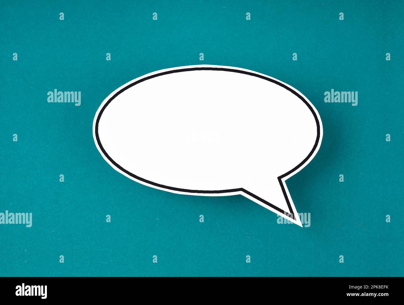 White speech bubble shaped post it note on green background with copy ...