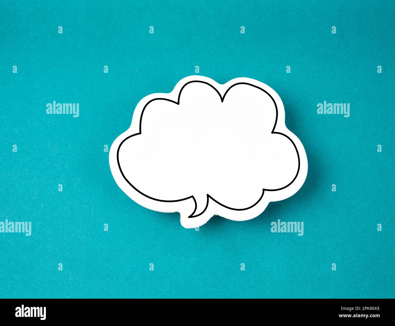 White speech bubble shaped post it note on green background with copy ...