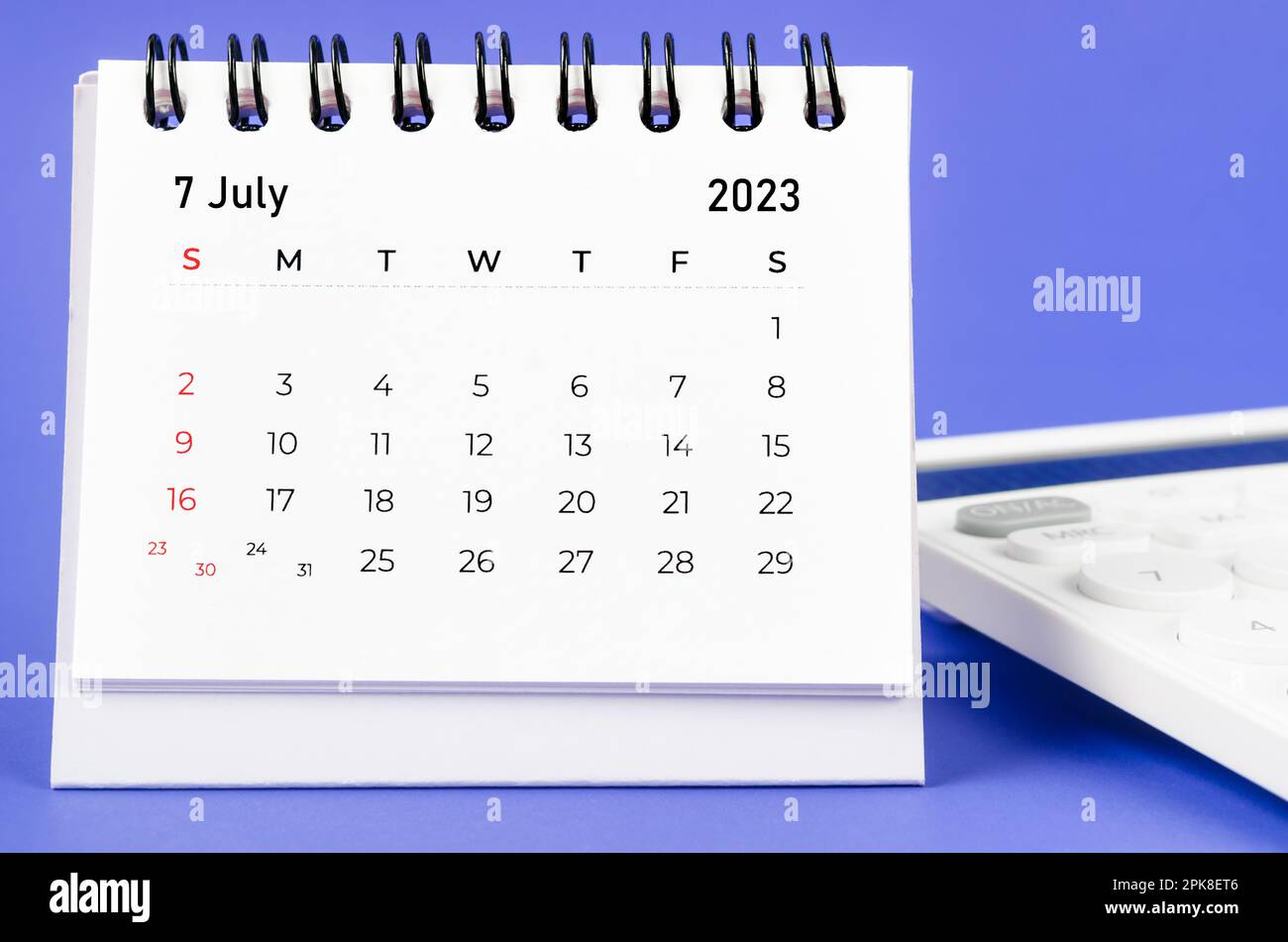 July 2023 Monthly desk calendar for 2023 year with calculator on purple ...
