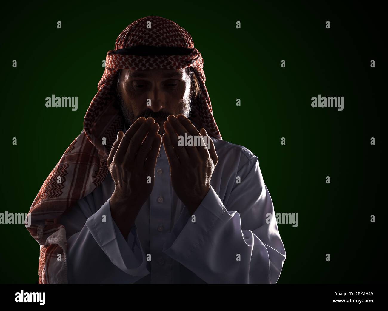 Arab man in prayer with his palms in front of his face. It conveys the ...