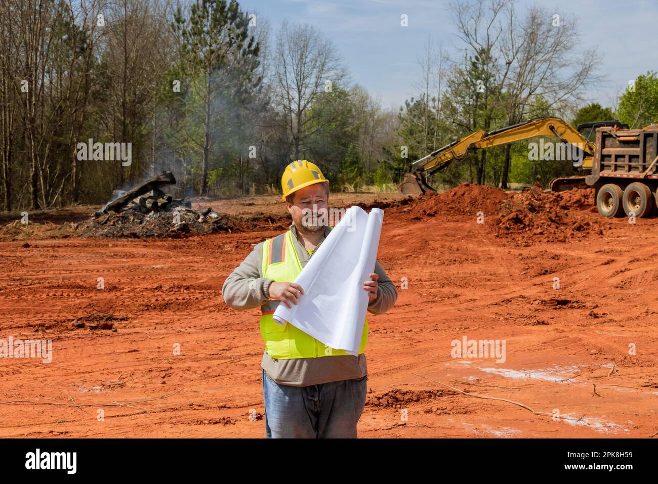 This supervisor in hard hat safety vest checking house project plan on ...