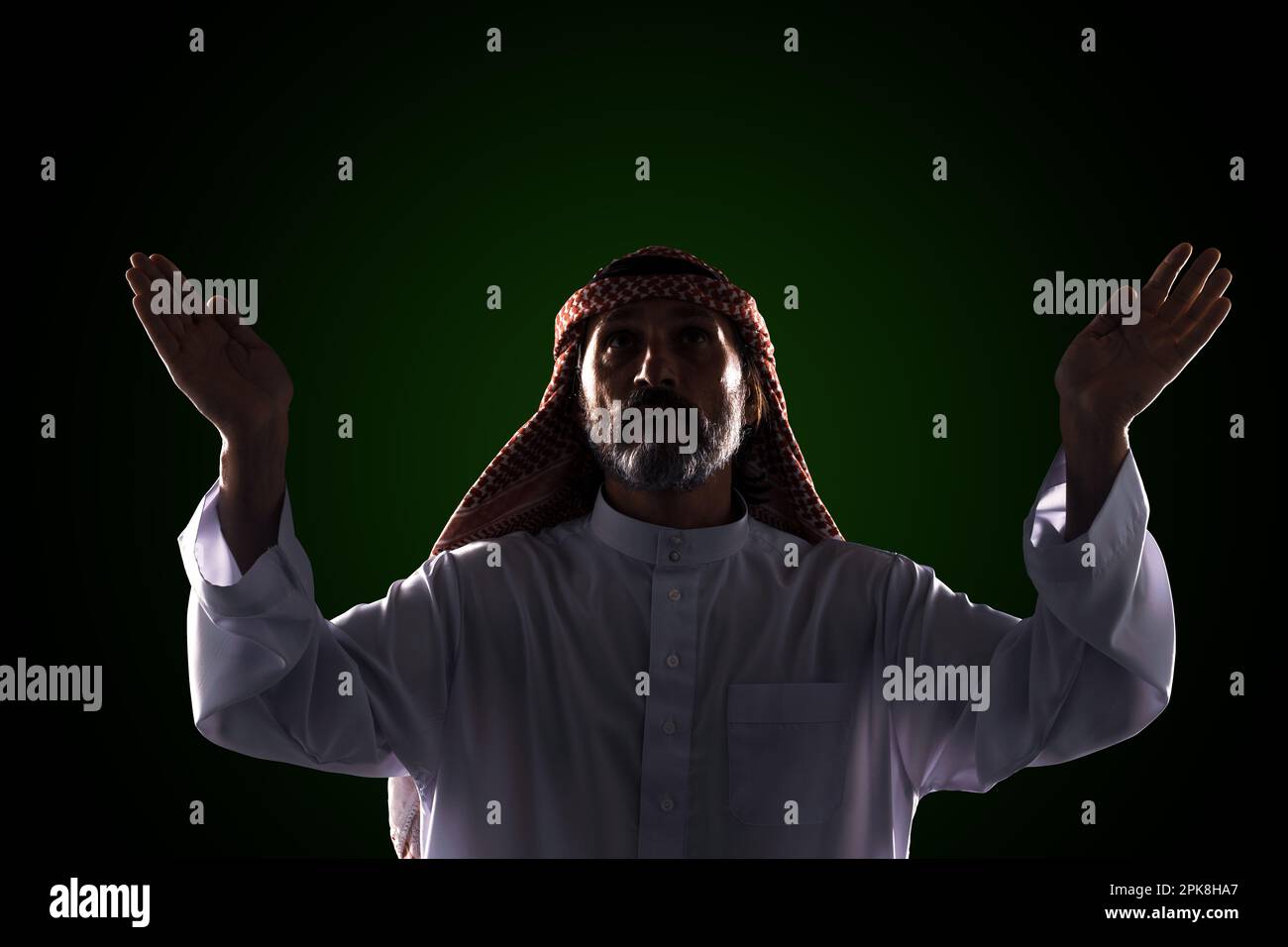 Muslim man raises his hands to sky in prayer and praise, expressing his ...