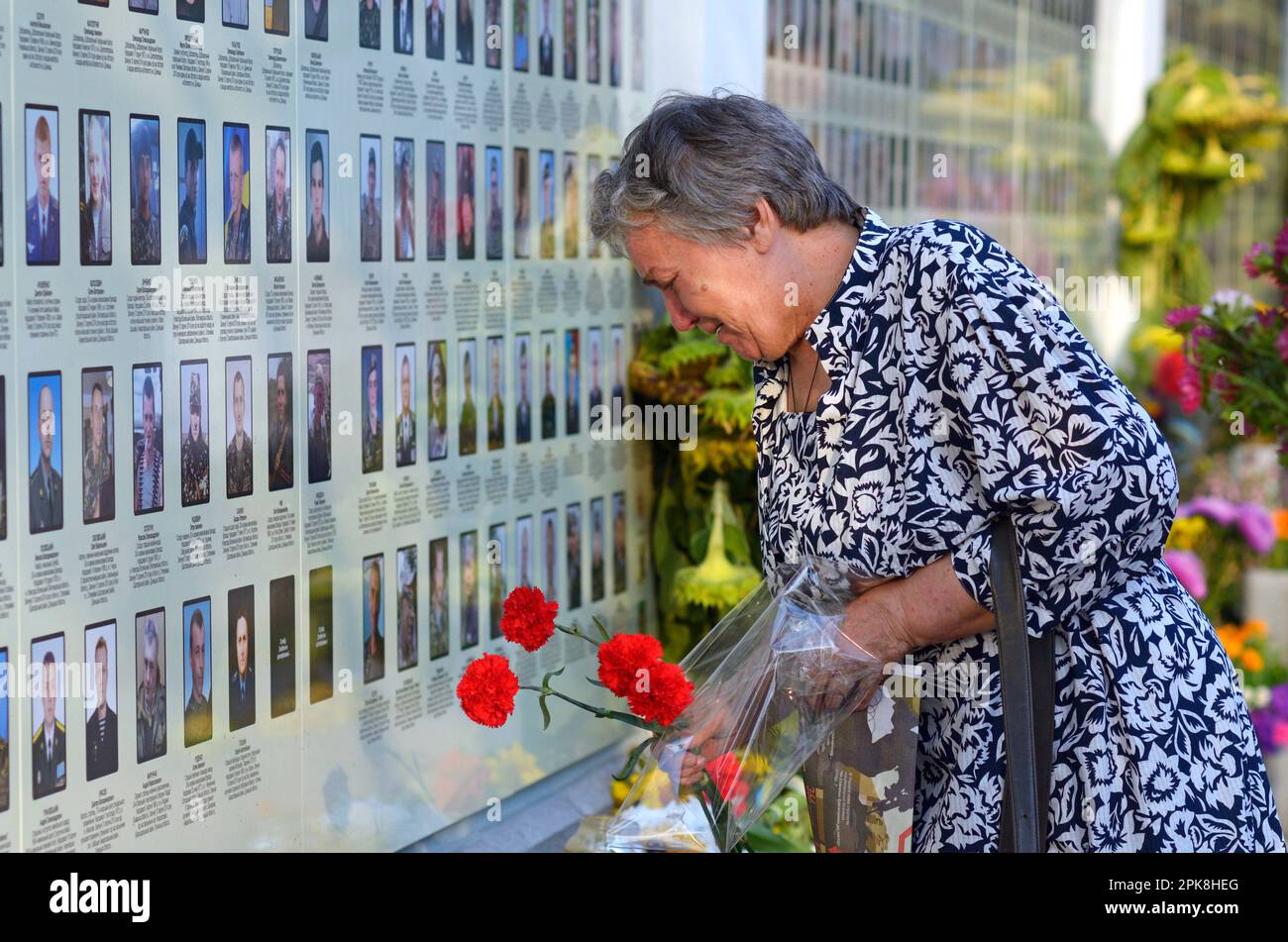 Woman crying in front of the Wall of Remembrance put flowers. Meeting ...