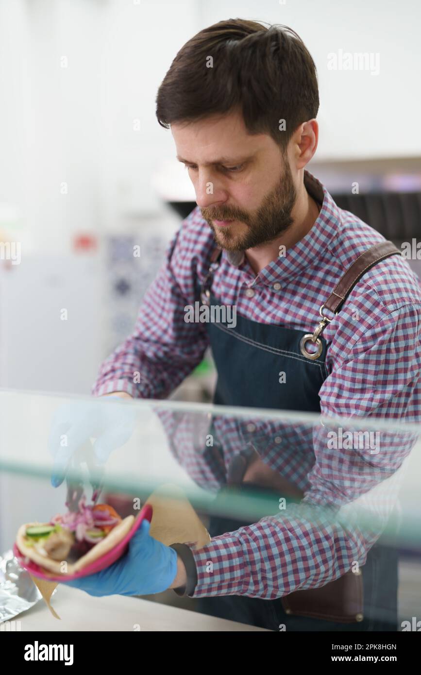 White man with beard working in a commercial kitchen. Male cook ...