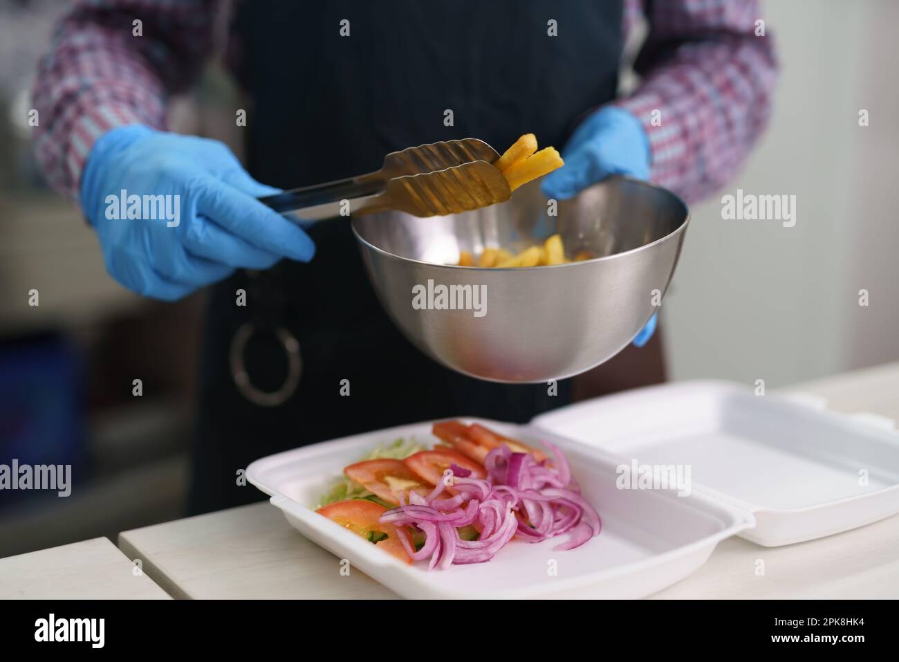 Cook preparing lunch box in a diner. Chef cooking traditional Greek ...