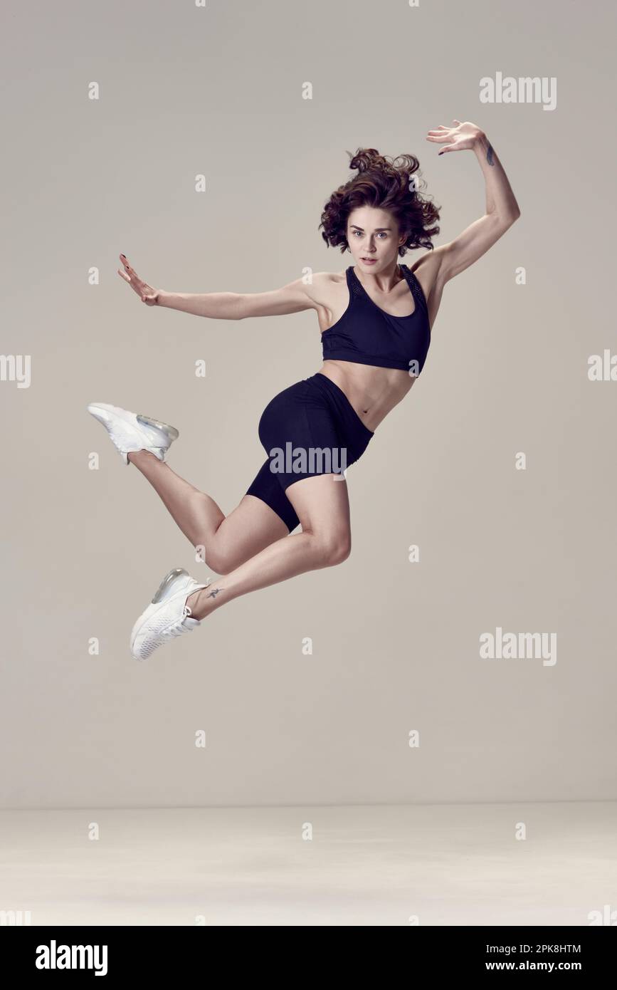 Full-body workout. Dynamic image of young beautiful woman in sportswear ...