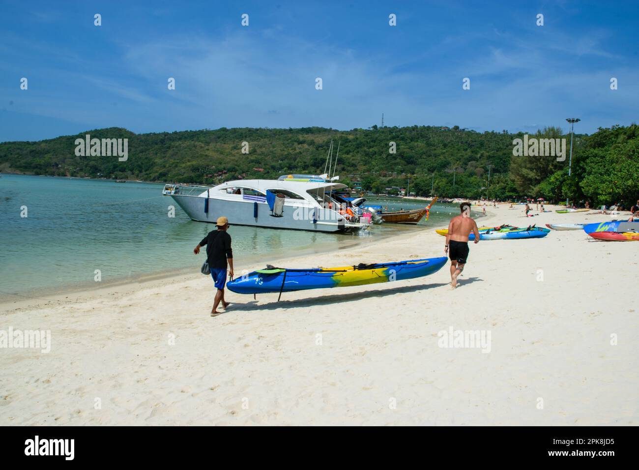 Two people carrying a canoe at the beach Stock Photo - Alamy