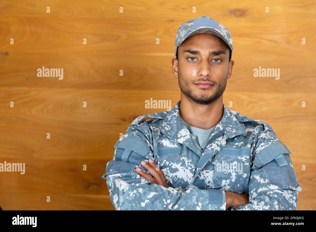Portrait of biracial male soldier wearing military uniform and cap ...