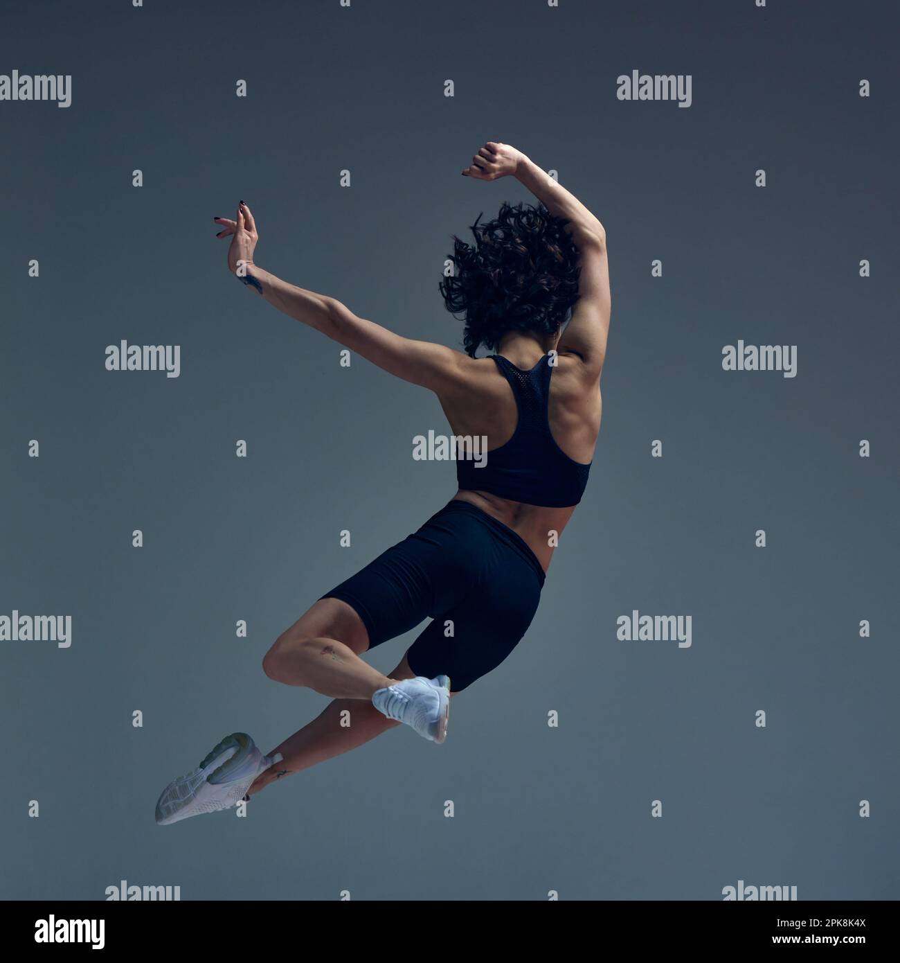 High jump. Relief back, Dynamic image of young beautiful woman in ...