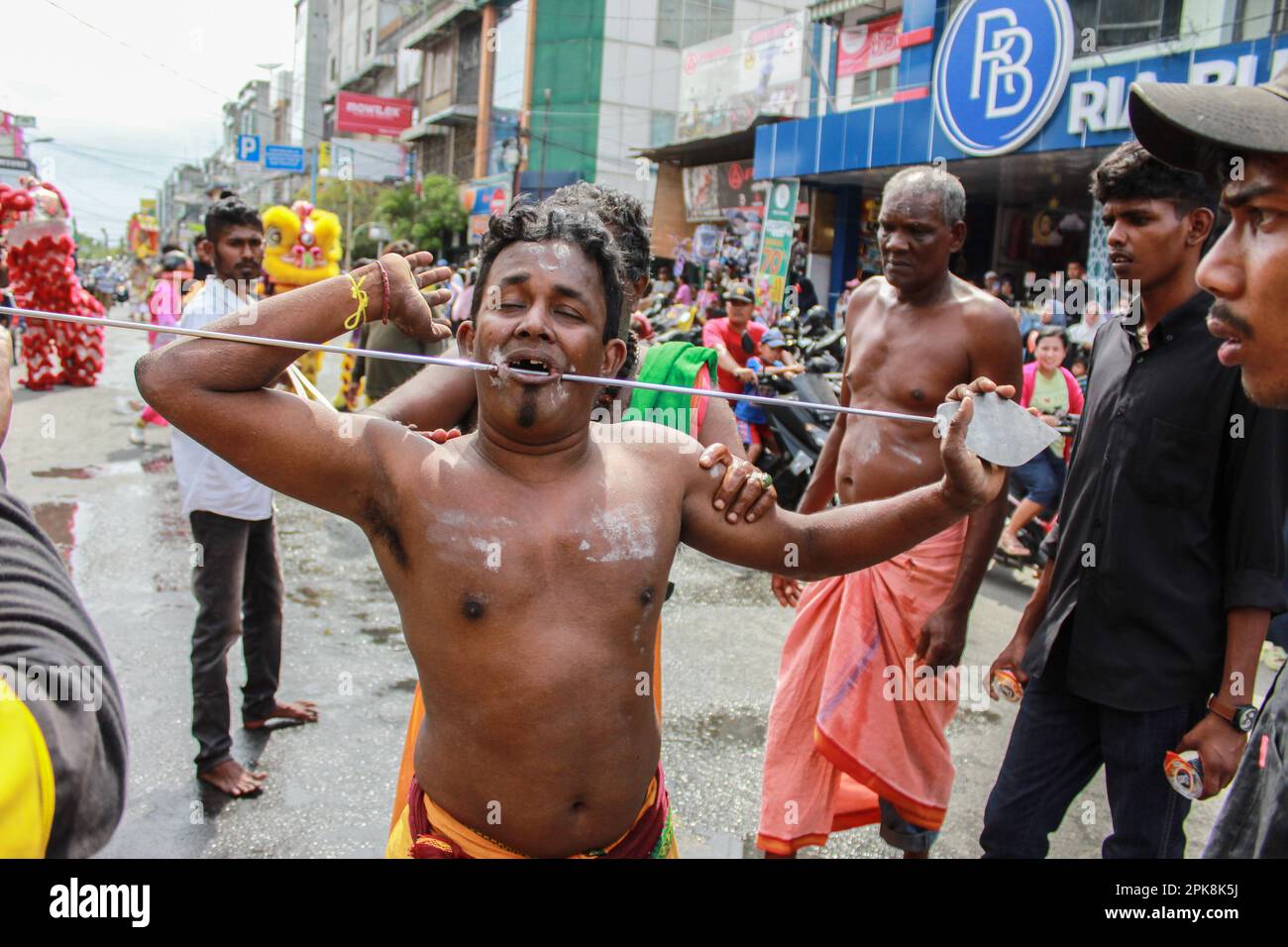 A Tamil Hindu participates in the cheek and body piercing ritual during ...
