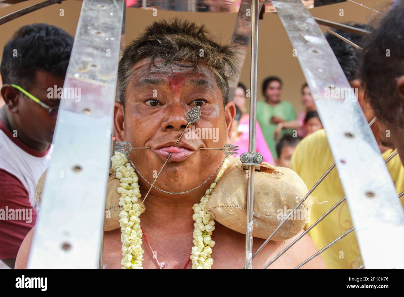 A Chinese resident participates in the tongue piercing ritual during ...