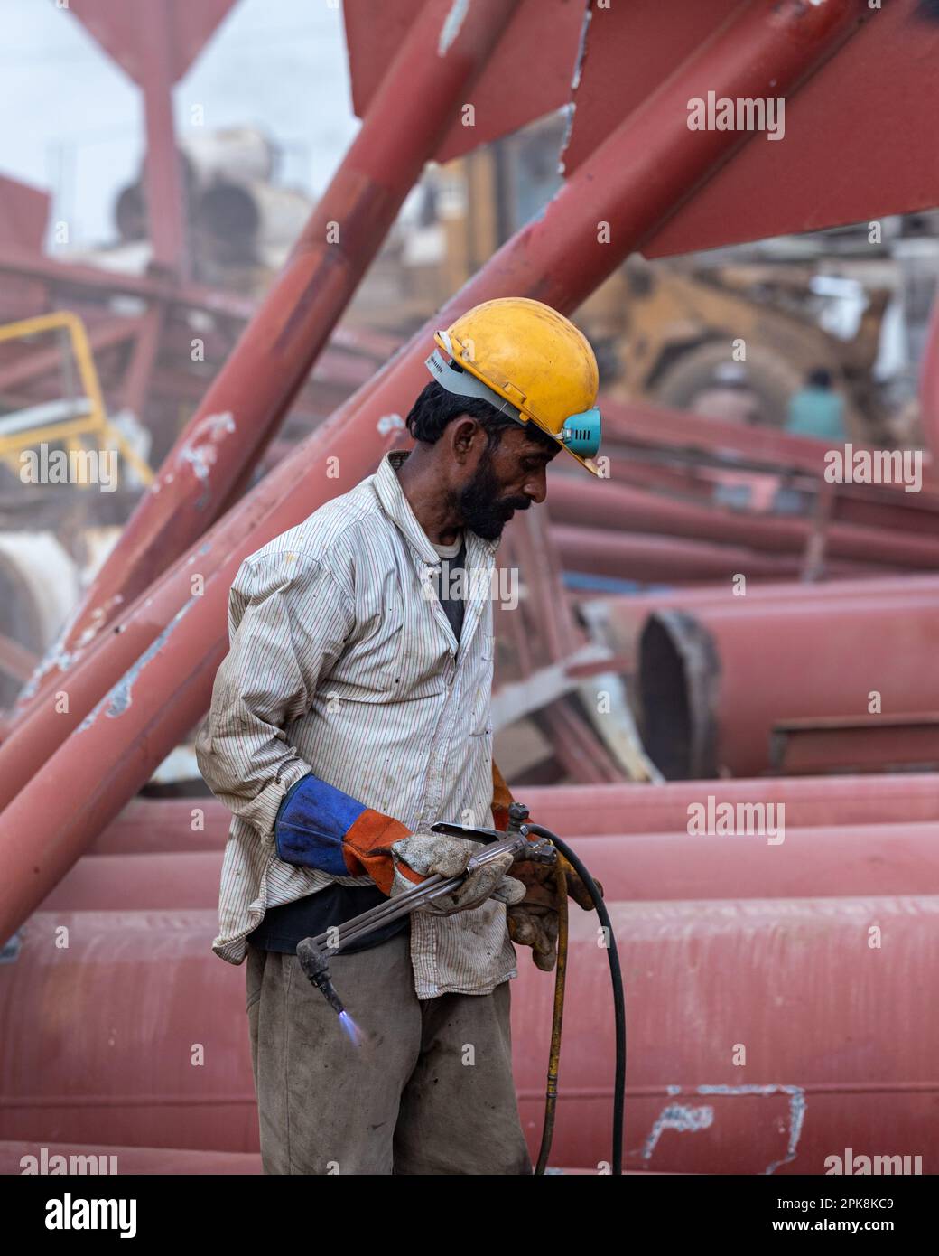 Gadani Pakistan August 2021, a worker wearing red safety helmet working ...