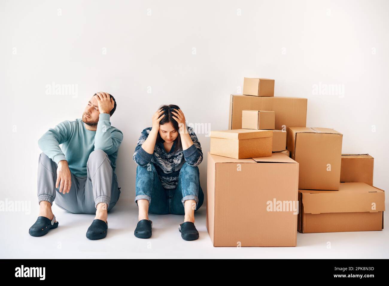Young couple fell asleep after a moving day sitting on the floor ...