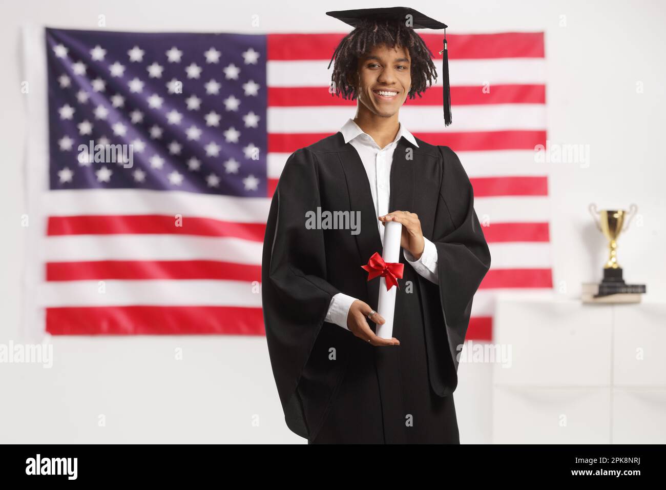 African american male student in a graduation gown holding a diploma ... African american male student in a graduation gown holding a diploma ...
