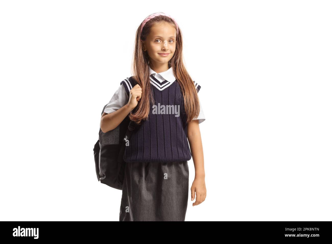 Schoolgirl in a uniform carrying a backpack isolated on white ...