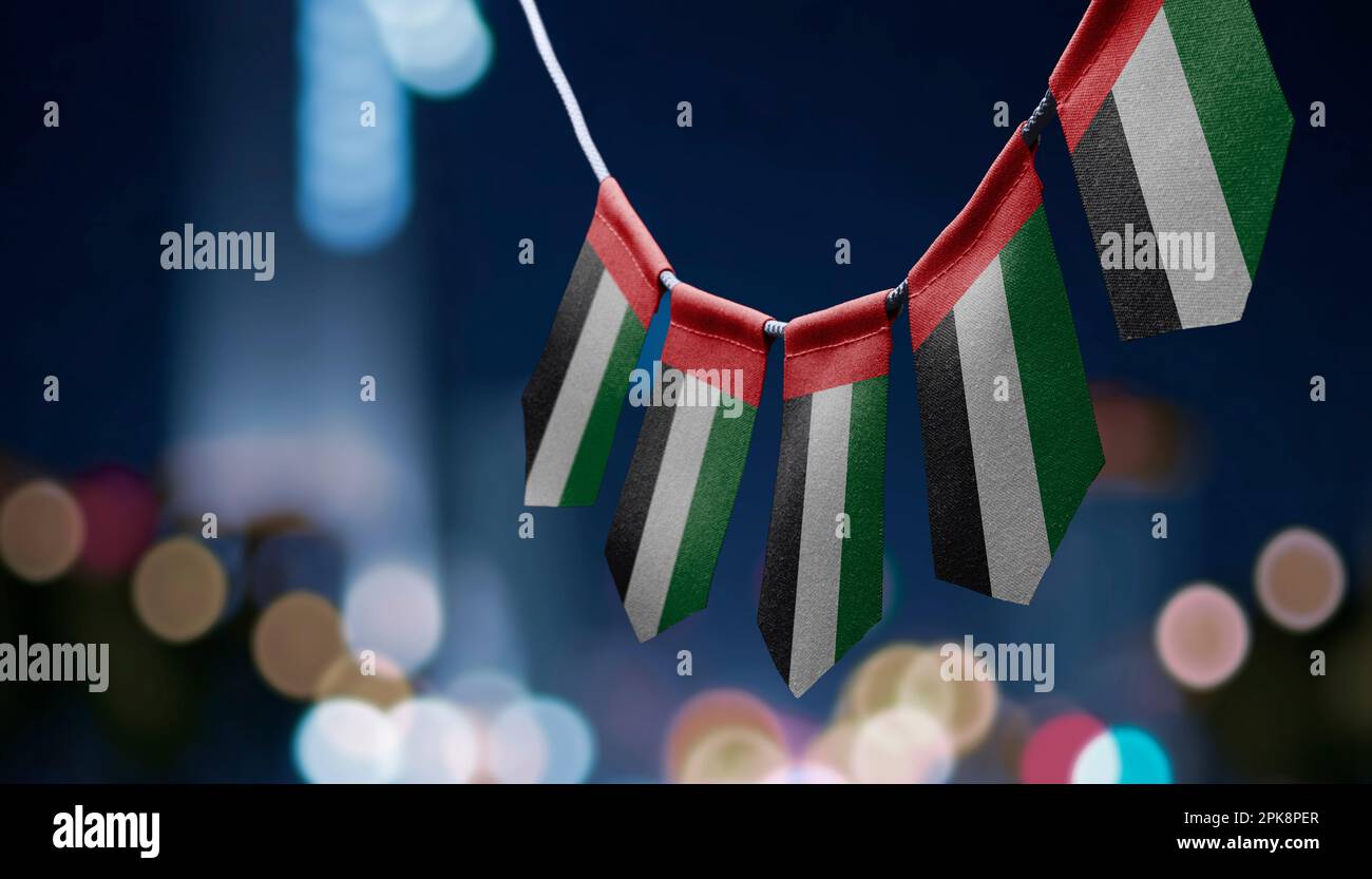 A garland of United Arab Emirates national flags on an abstract blurred ...