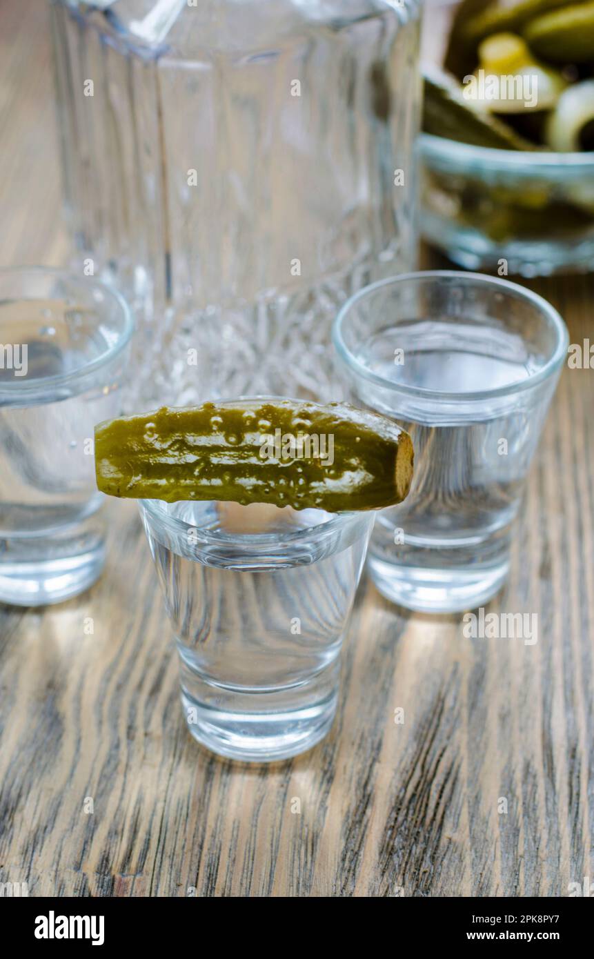 Vodka in a glass and pickled cucumber. Traditional Russian alcoholic ...