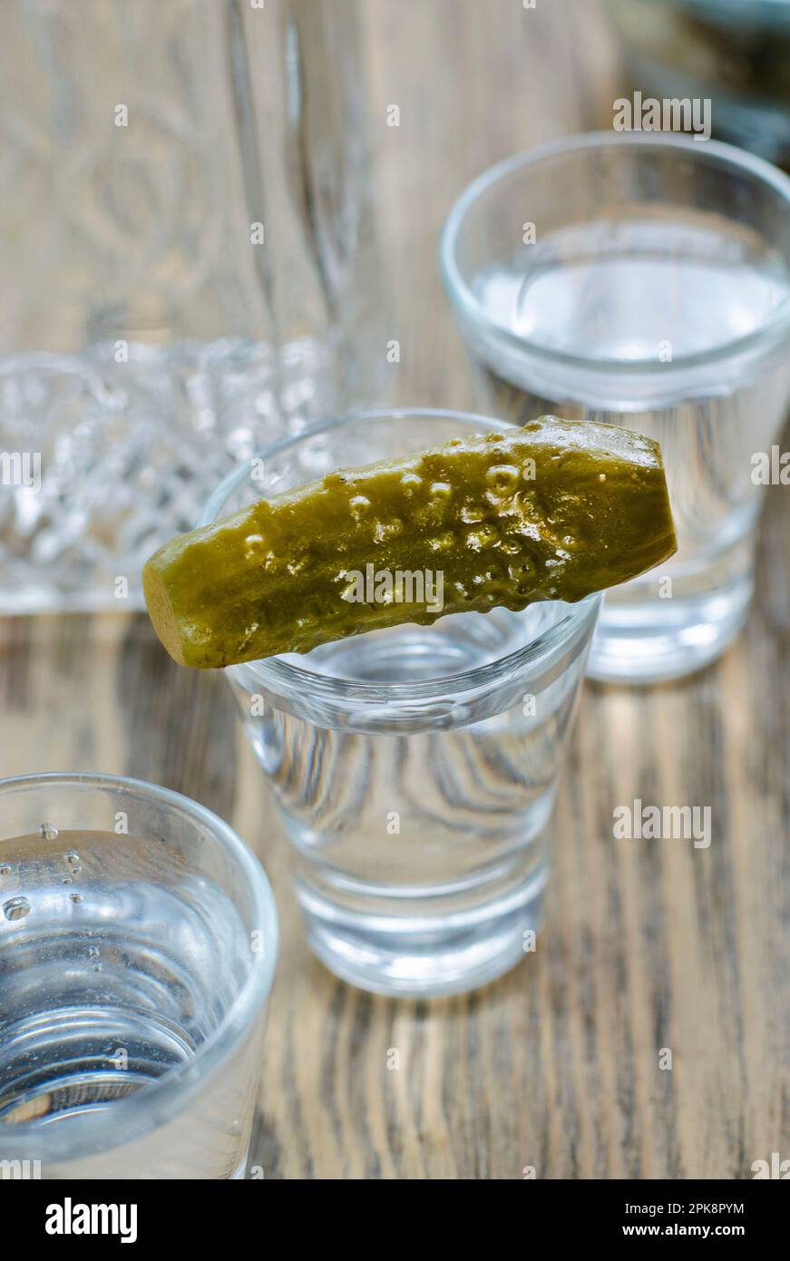 Vodka in a glass and pickled cucumber. Traditional Russian alcoholic ...