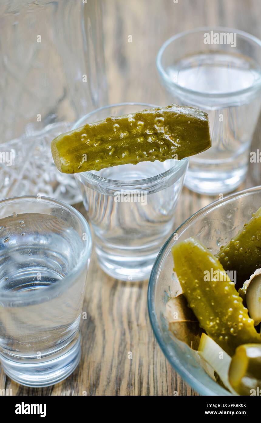 Vodka in a glass and pickled cucumber. Traditional Russian alcoholic ...