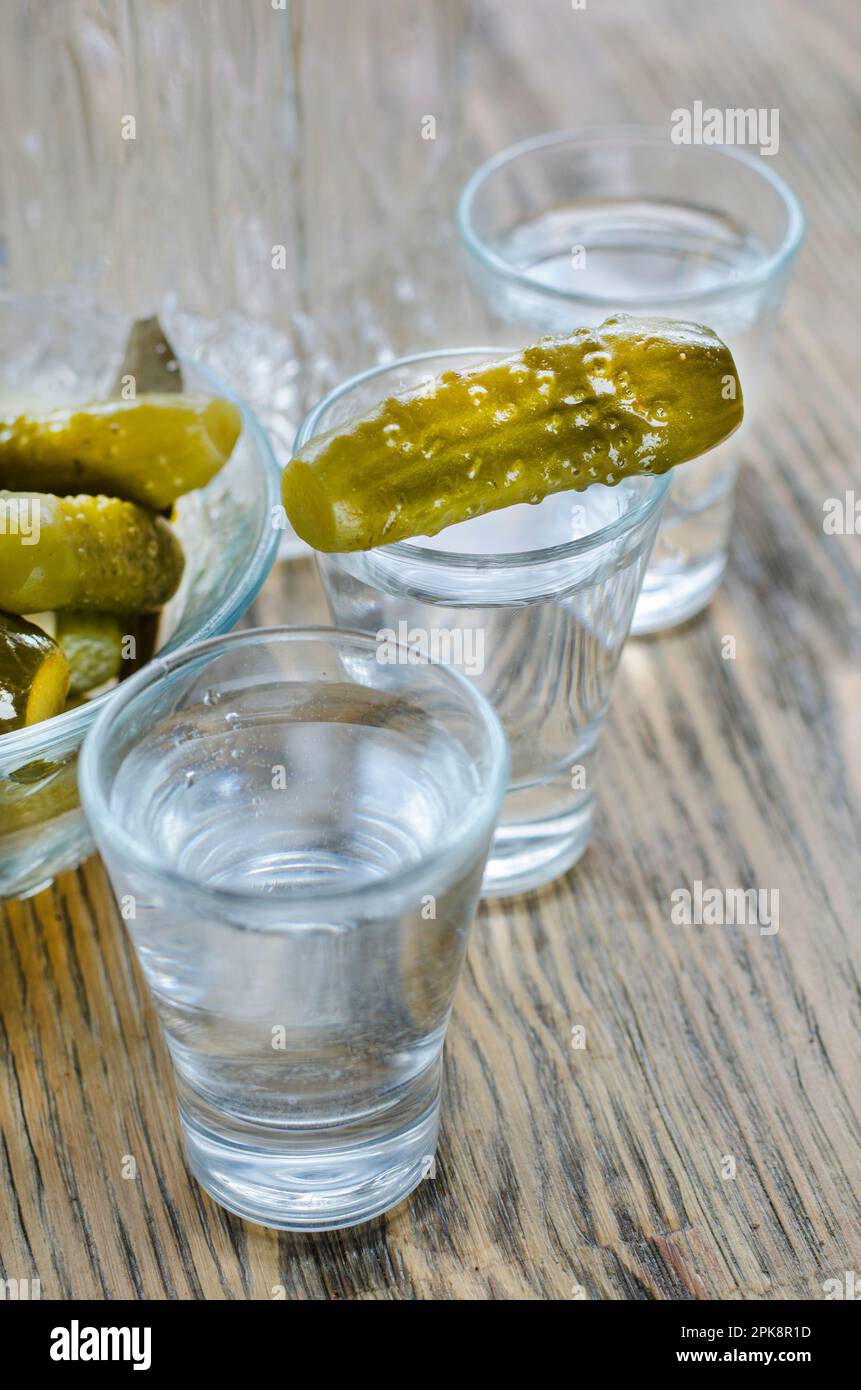 Vodka in a glass and pickled cucumber. Traditional Russian alcoholic ...