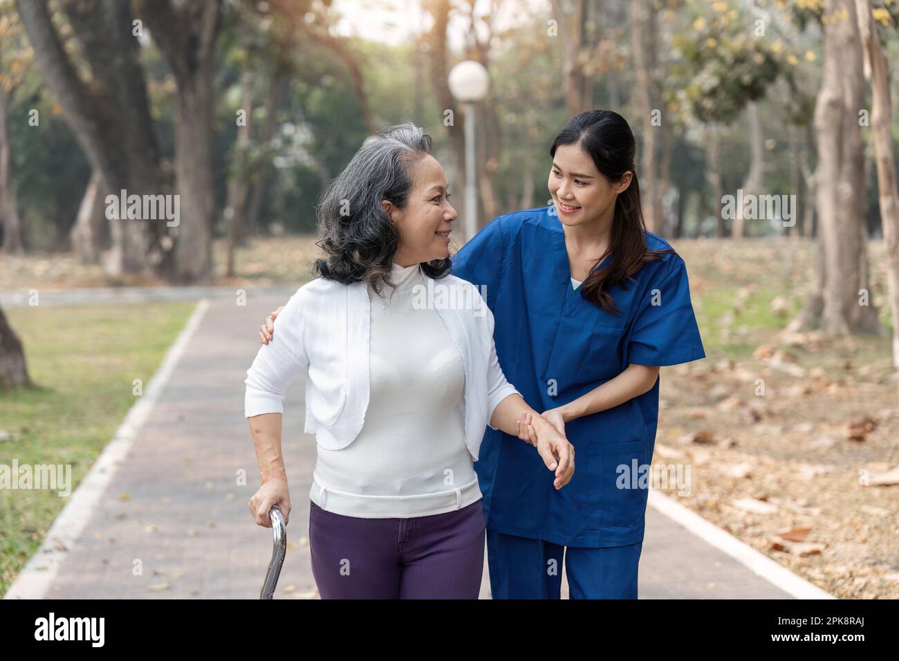 nurse helping elderly woman with walker Nurse holding hand and help ...