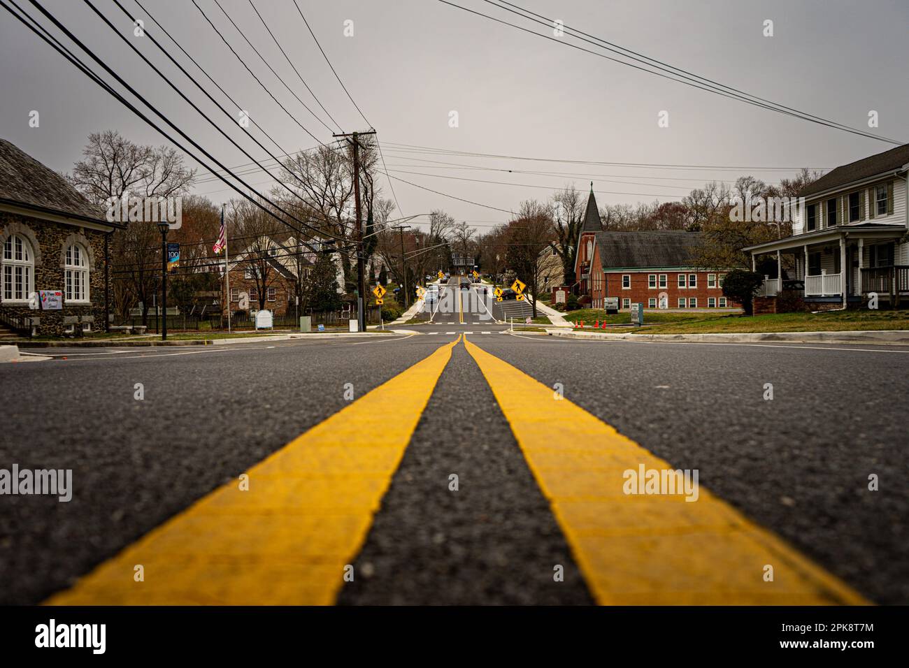 A street lined with residential homes, with yellow painted lines ...