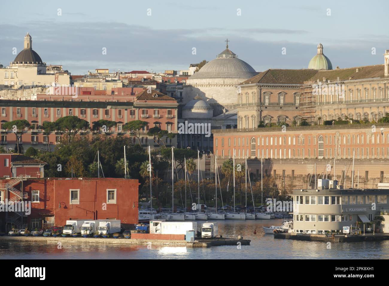 A group of boats in a body of water in front of the buildings in Naples ...