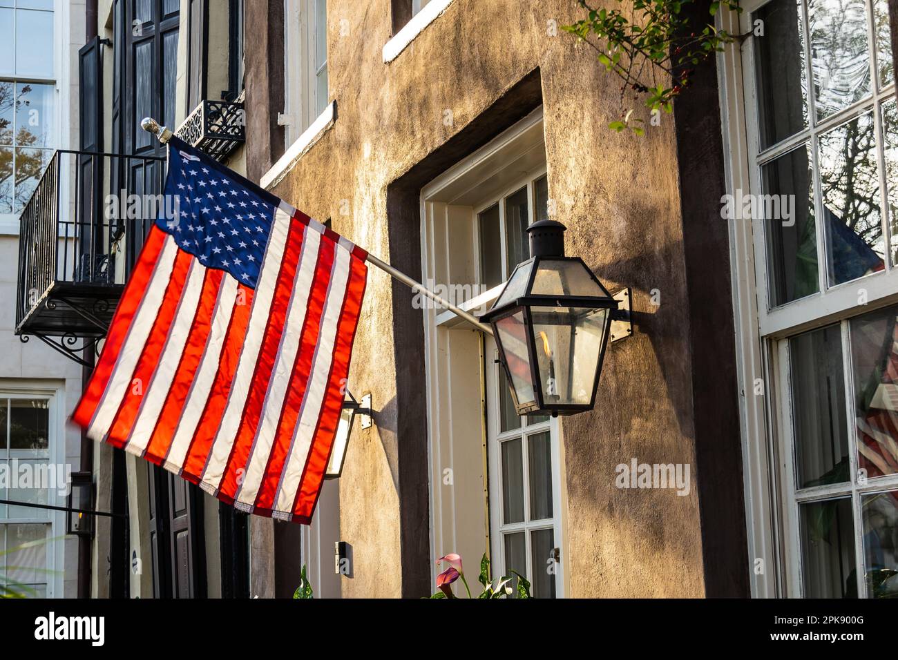 An American Flag hanging outside of a colonial era home in morning ...