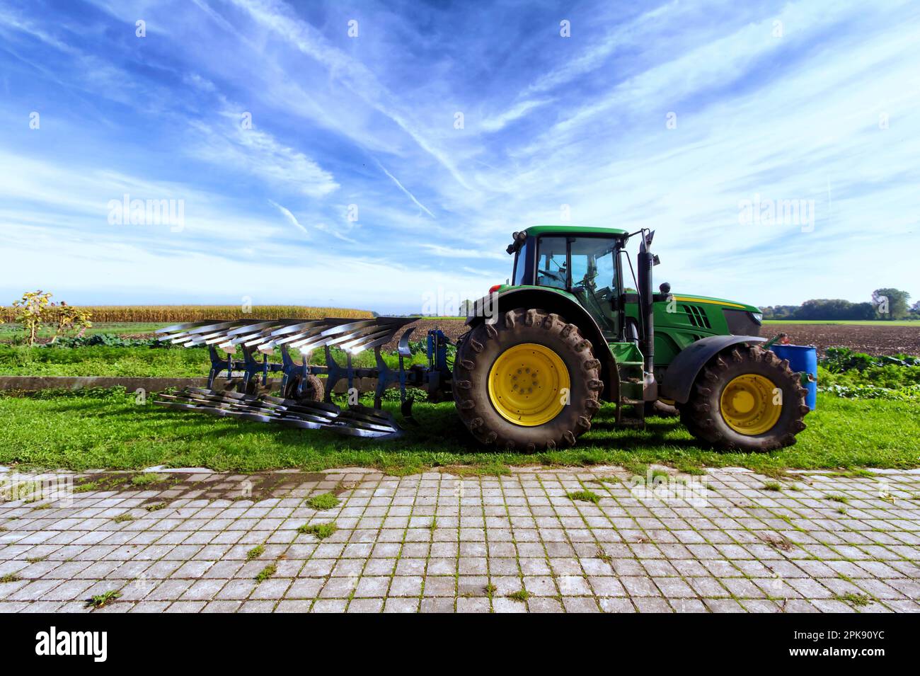 Tractor with plow attached standing in backyard of farm with dramatic ...