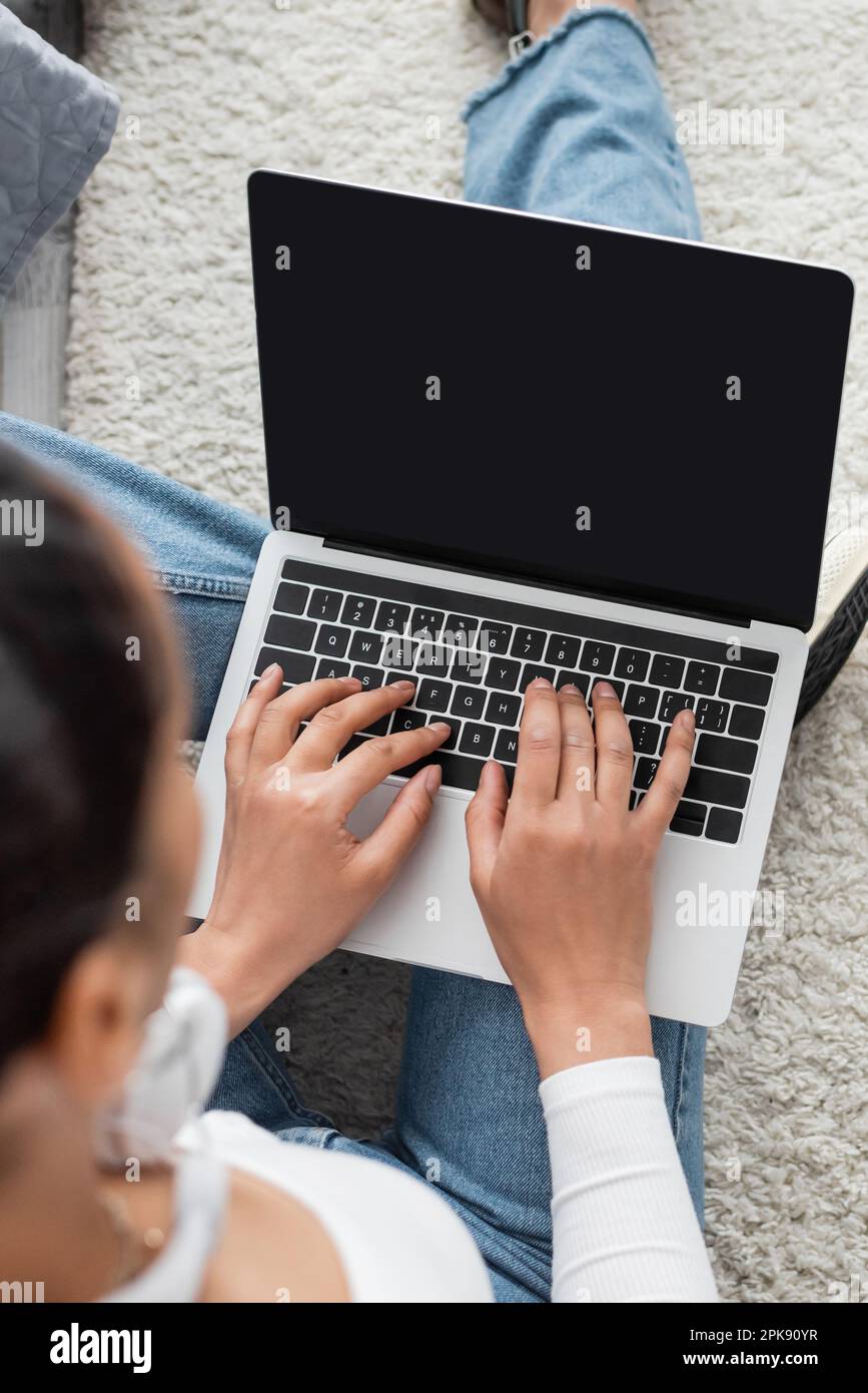 top view of african american woman typing on laptop keyboard while ...
