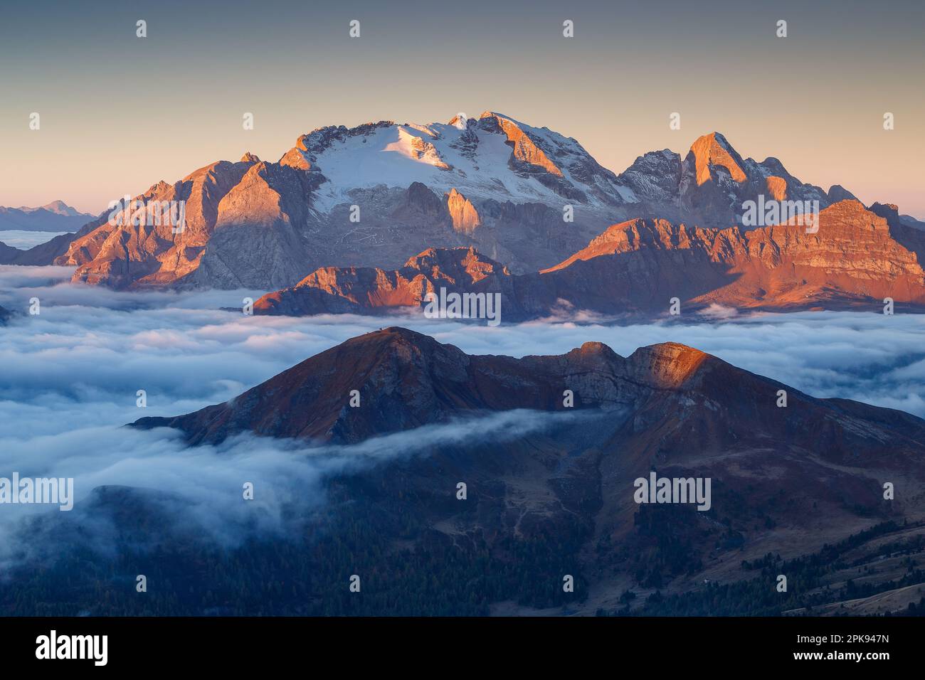 Alpenglow at dawn on the Marmolada mountain group. Reddish colors on ...