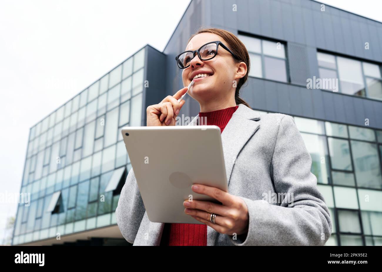 Woman freelance designer holding digital tablet in hands and smiling ...