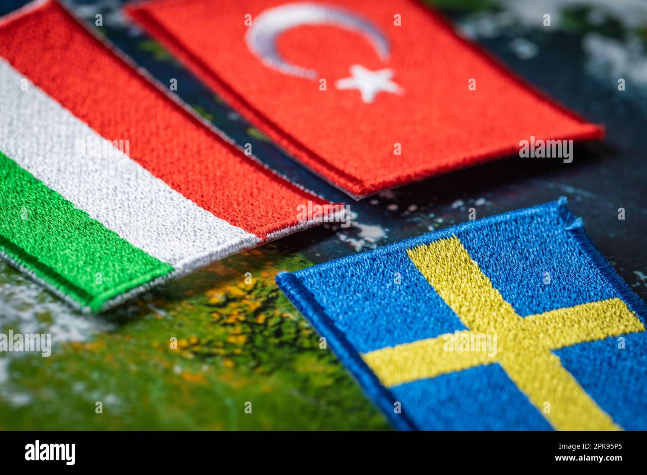 The flags of Turkey and Hungary in front of the symbol of Sweden. The ...
