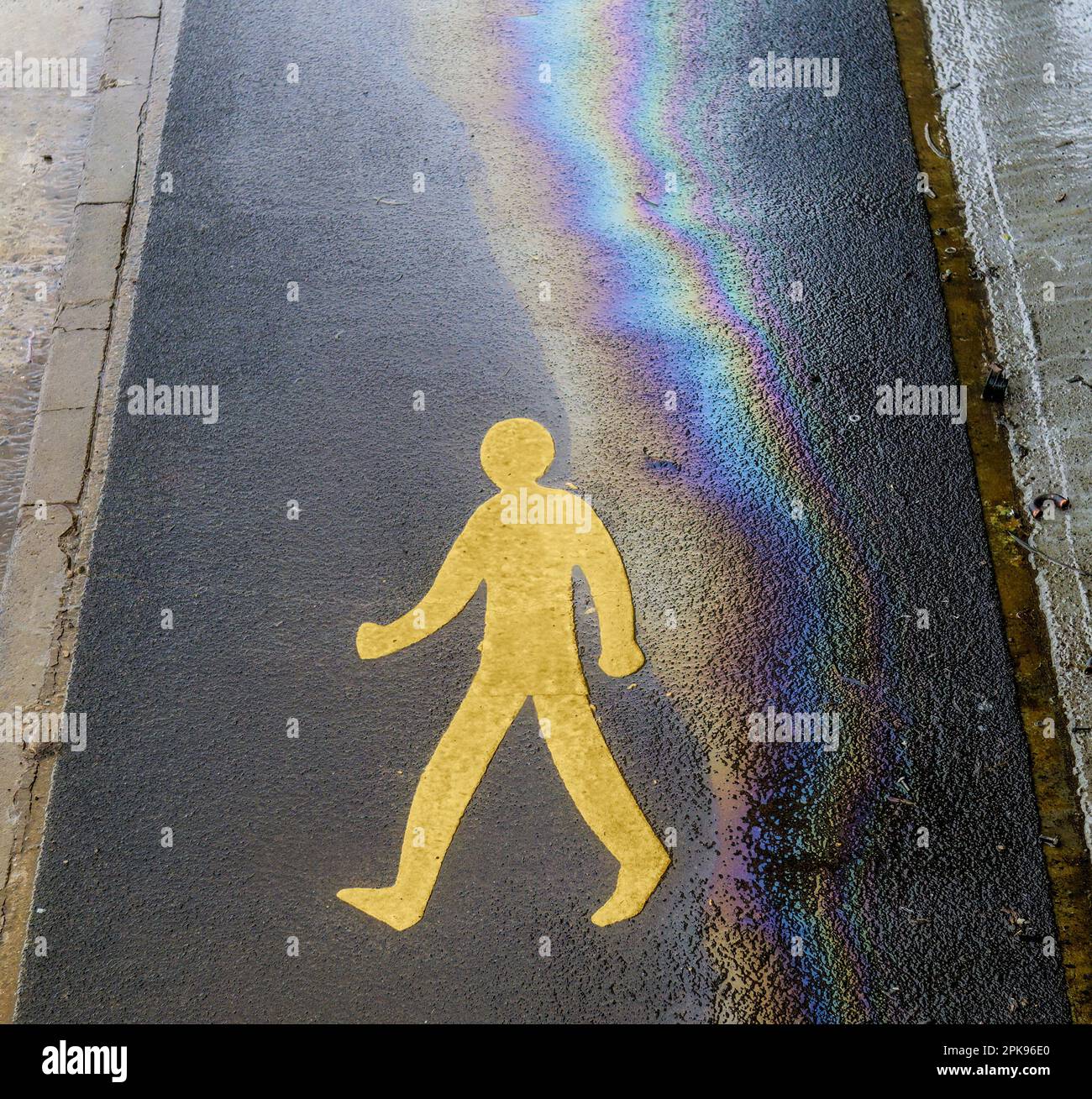 Pedestrian pavement sign with oil and water rainbow effect on asphalt ...