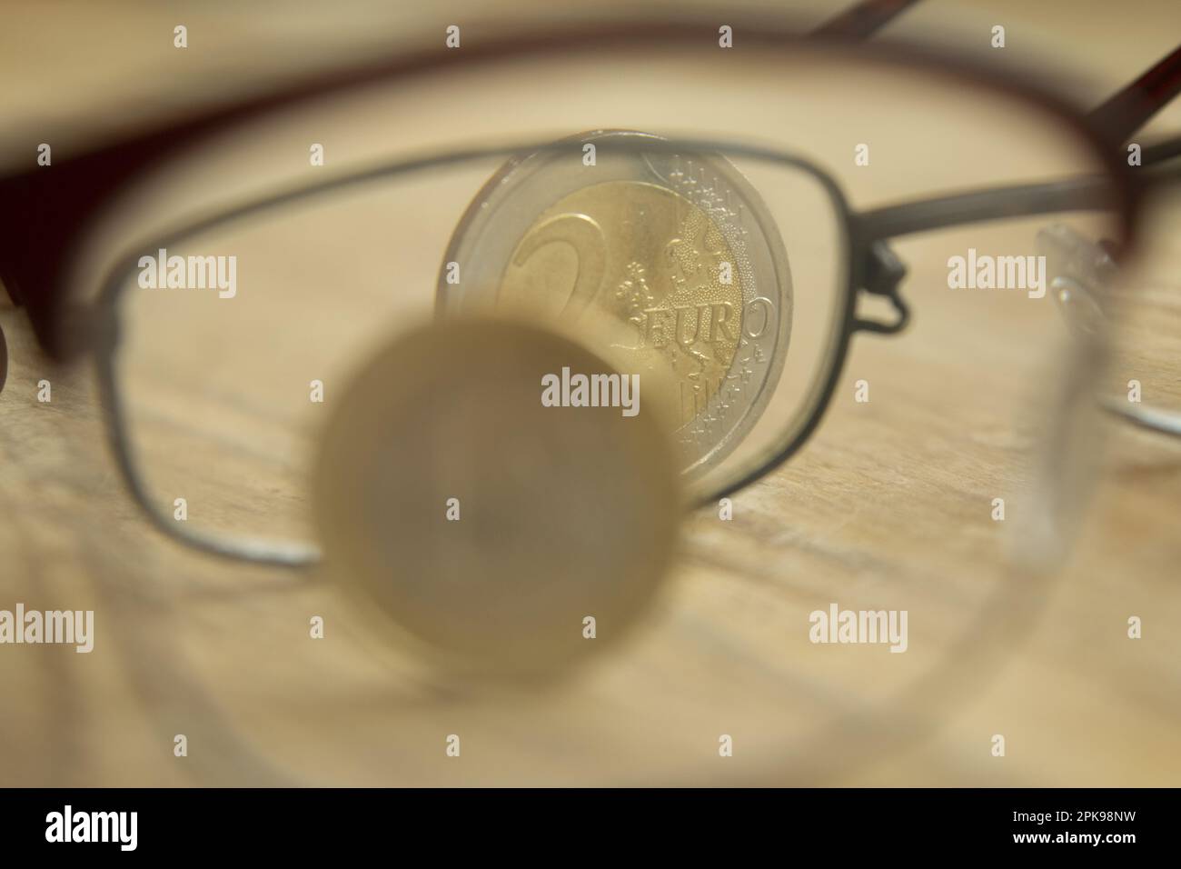 smart business concept with coins of various value seen through glasses ...