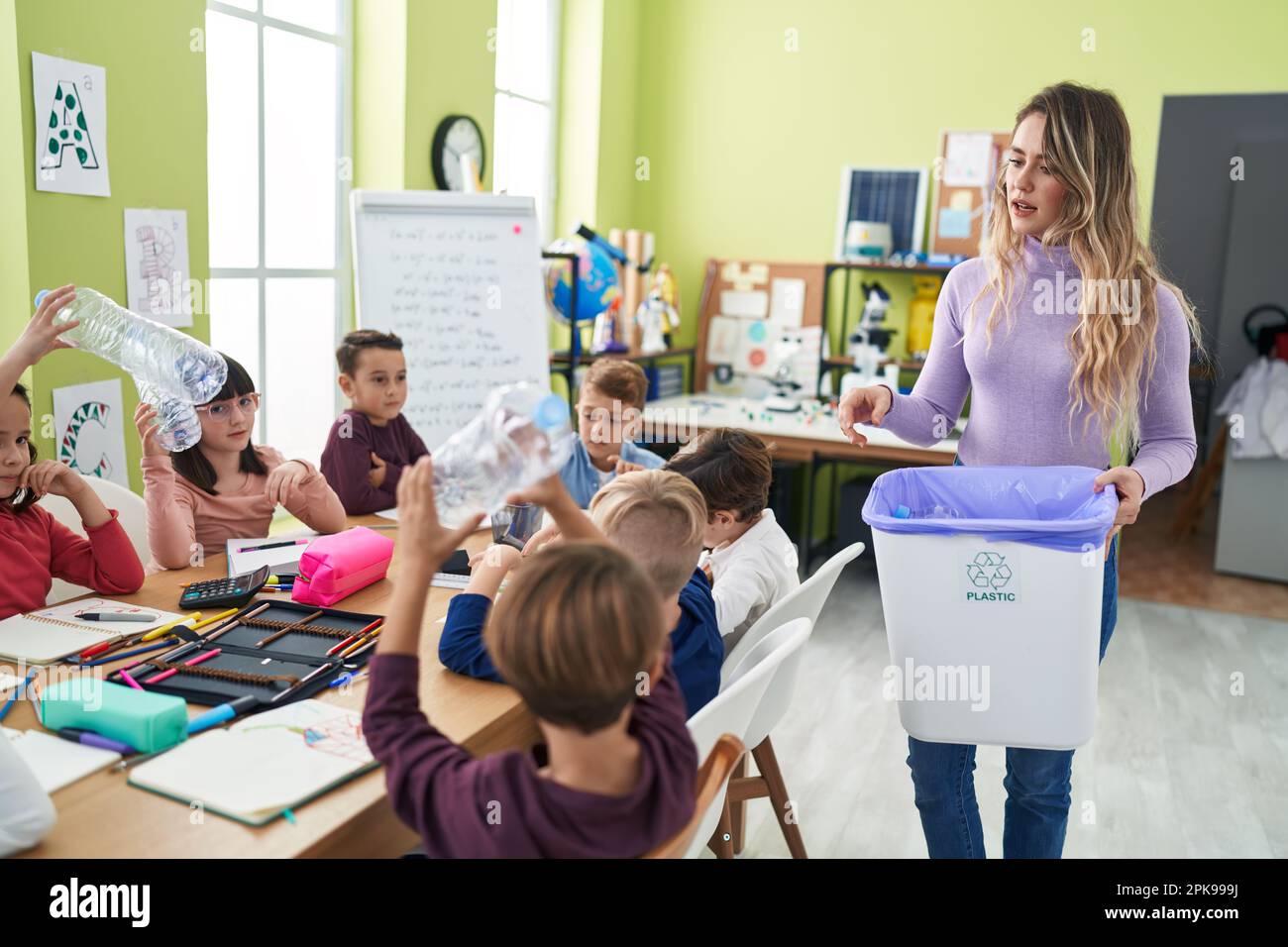 Woman and group of kids throwing plastic bottle on paper bin recycling ...