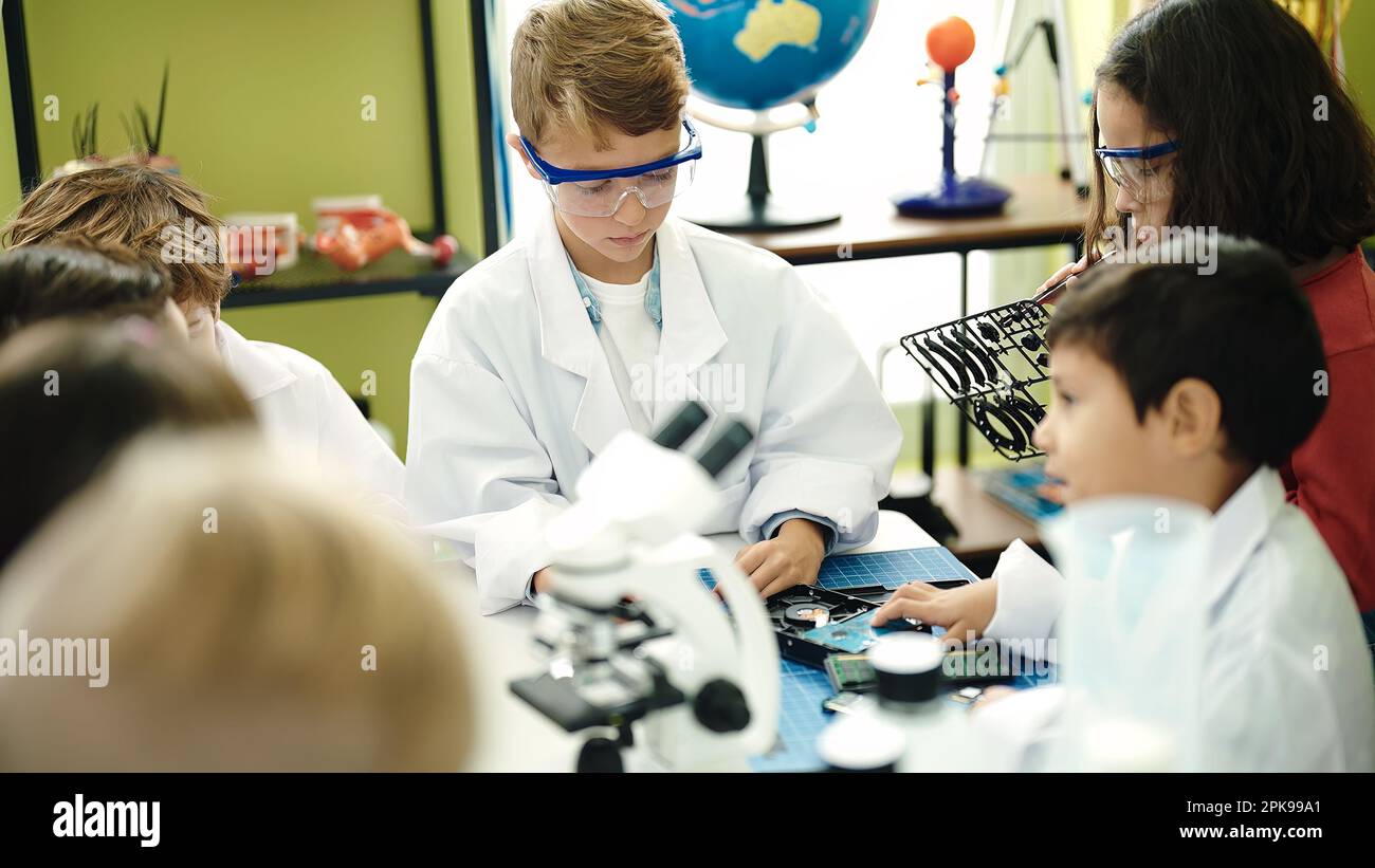 Group of kids students using microscope repairing gadget at laboratory ...