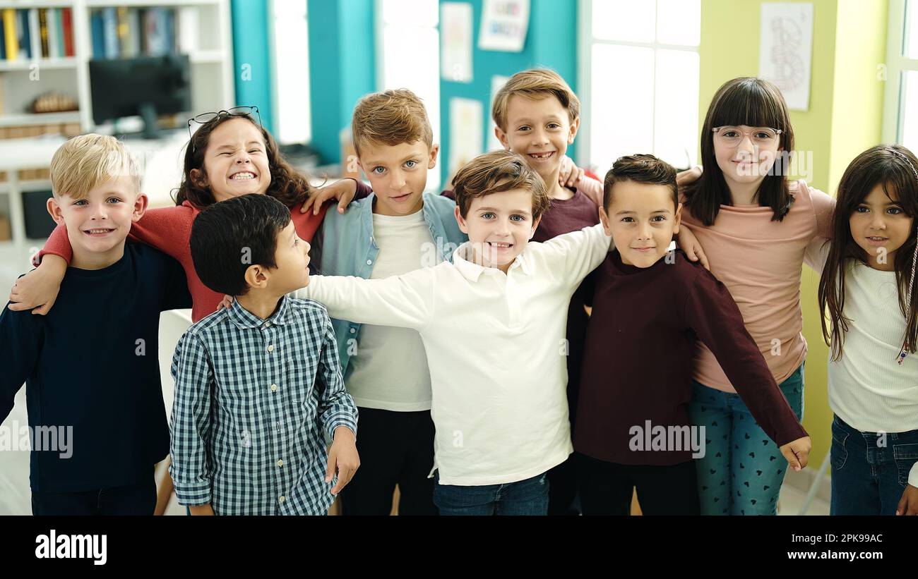 Group of kids students smiling confident hugging each other at ...