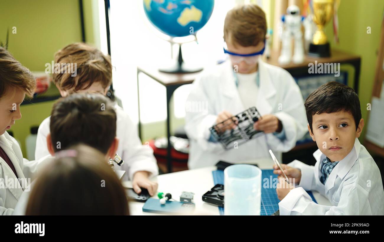 Group of kids students using microscope repairing gadget at laboratory ...