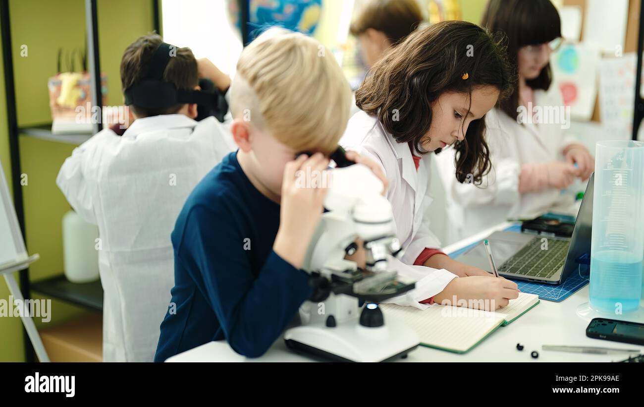 Group of kids students using microscope at laboratory classroom Stock ...