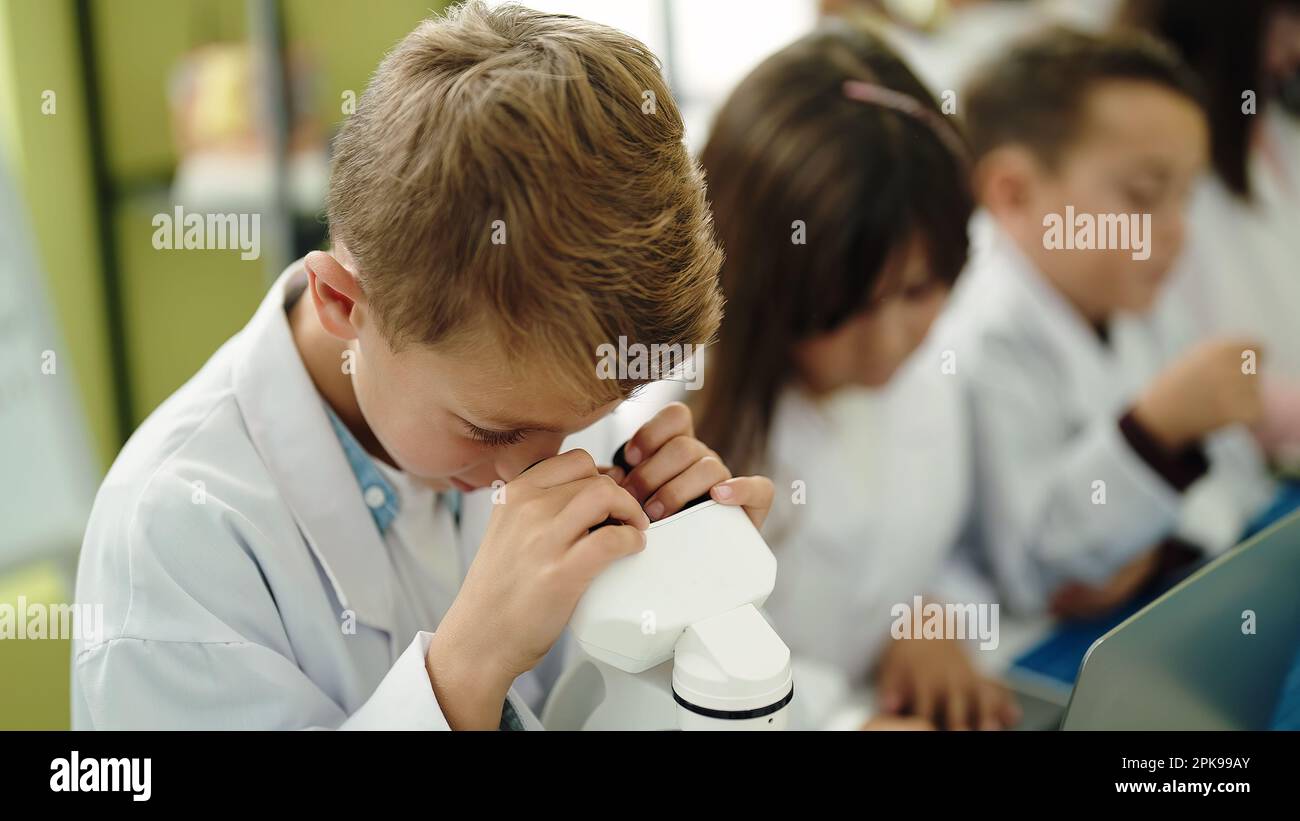 Group of kids students using microscope at laboratory classroom Stock ...